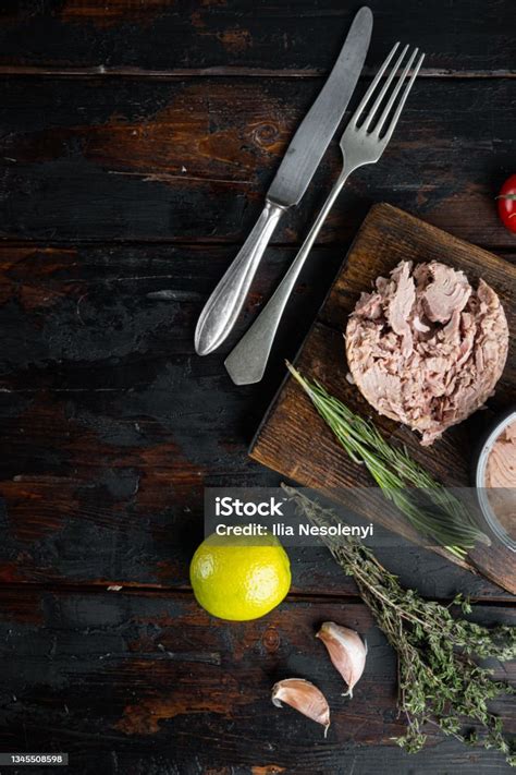 오래된 어두운 나무 테이블 배경에 나무 도마에 통조림 이탈리아 참치 허브와 재료로 상단 보기 플랫 누워 카피 스페이스와 텍스트