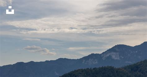 나무와 산으로 둘러싸인 집이있는 작은 섬 사진 Unsplash의 무료 땅 이미지
