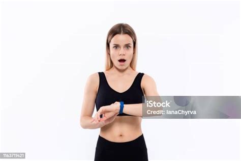 흰색 배경 위에 서 운동 후 맥박을 확인 하는 스마트 시계를 보고 검은 스포츠웨어에 젊은 스포티 한 금발 여자 놀라움에 대한 스톡 사진 및 기타 이미지 Istock