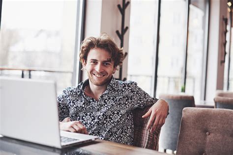 커피 한잔과 함께 사무실에 앉아 프로젝트에 노력 하 고 젊은 잘생긴 남자 현대 사이버 기술로 연결 디지털 마케팅 분야에서 마감을 유지 하려고 노트북 사업 개발에 대한 스톡