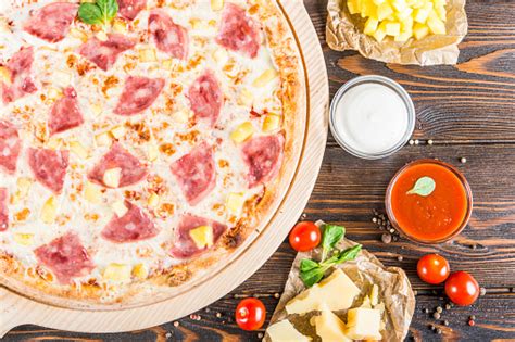 백색과 빨강 소스입니다 햄과 어두운 나무 배경에 라운드 커팅 보드에 파인애플 피자 음식 재료입니다 매크로 0명에 대한 스톡 사진 및 기타 이미지 Istock