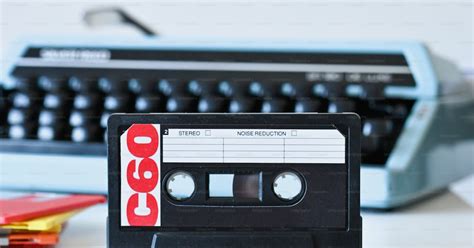 타자기 옆 탁자 위에 앉아 있는 구식 카세트 플레이어 사진 Unsplash의 믹스테이프 이미지