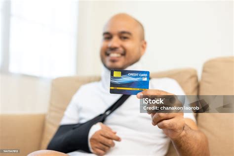 신용 카드를 사용하는 행복한 남자는 캐스트 넥 부목 칼라 슬링 지원 팔에 다리 부목으로 골절 골절 부러진 뼈 부상으로 의료비를 지불합니다 사회 보장 및 건강 보험 건강관리와