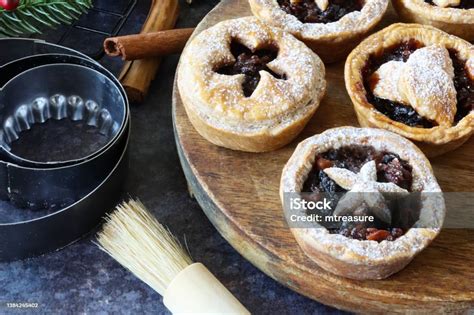 페이스트리 스타 상세 뚜껑 가문비 나무 바늘 붉은 열매 계피 스틱 페이스트리 커터와 브러시를 얹은 수제 다진 파이의 나무 도마의 전체 프레임 이미지 전경에 초점을 맞추고 0