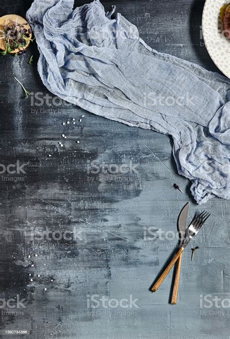 섬유와 식기류가있는 빈 회색 돌 배경 소박한 스타일의 음식 배경 주방 수건과 레몬이있는 시멘트 테이블 미적 최소한의 배경 냅킨에