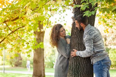 Young Couple Having Fun In Autumnal Woods Couple Peeking From B Stock