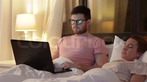 Man Using Laptop While Girlfriend Is Sleeping Stock Video Colourbox