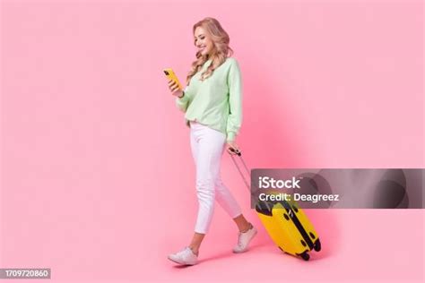 매력적인 쾌활한 사람의 전체 길이 프로필 사진은 여행 가방을 들고 분홍색 배경에 격리 된 스마트 폰 산책을 사용합니다 20 24세에 대한 스톡 사진 및 기타 이미지 Istock