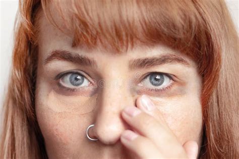 Close Up Photo Of Woman Applies Concealer With Her Finger Under Her