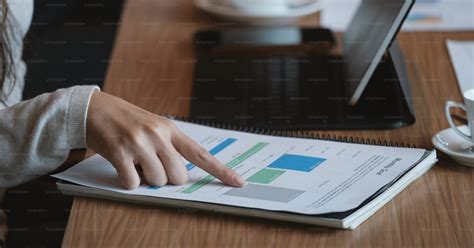 펜을 들고 그래프 용지를 들고 있는 사업가가 월간 목표에 대한 판매를 계획하기 위해 만나고 있습니다 사진 Unsplash의 개 이용 후기 이미지