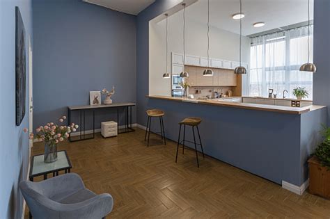 미니멀리스트 현대 인테리어 디자인 중앙에 기둥이있는 흰색 파란색 및 진한 파란색 색상의 스칸디나비아 스타일의 오픈 플랜이있는 거대한 밝은 아파트입니다 주방 공간 사무실 및