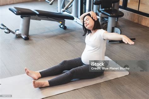 요가룸의 피트니스 센터에서 활동적인 임산부 운동을 합니다 임신 한 배에 아기를 들고 젊은 기대 어머니 출산 전 관리 및 여성 임신 개념 건강한 생활방식에 대한 스톡 사진 및