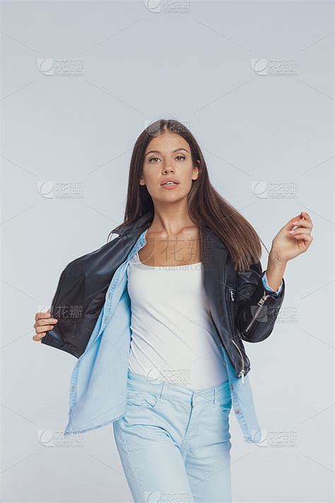 美丽的时装模特调整她的皮夹克，而行走