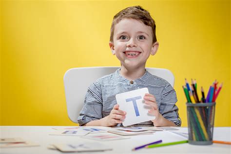 행복한 미소 짓는 작은 유치원 소년은 학교가 시작되기 전에 아침에 집에서 숙제를하는 편지를 보여줍니다 아이들을위한 영어 학습 2 3 살에 대한 스톡 사진 및 기타 이미지