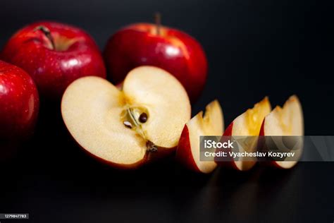 화면 중앙에는 슬라이스 조각과 붉은 육즙이 많은 사과의 절반이 있습니다 위의 전체 과일입니다 어두운 배경 배경 주제에 대한 스톡 사진 및 기타 이미지 Istock