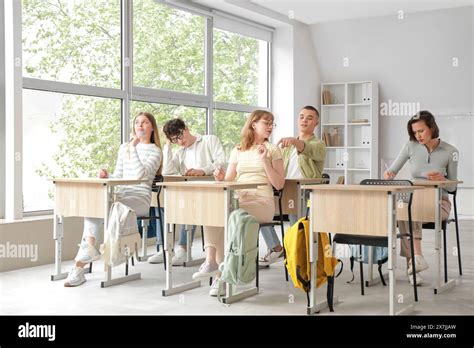 Male Student Asking Classmate For Help During Exam In Classroom Stock Photo Alamy