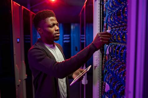 Premium Photo Concentrated Young Black Man Using Tablet While Examining Datacenter Equipment