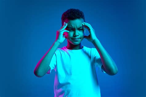 감정적 인 어린 소년의 스튜디오 샷 네온 라이트에서 푸른 배경에 고립 된 다양한 감정을 표현하는 아이 교육 어린 시절 현대 생활 방식 8 9 살에 대한 스톡 사진 및 기타