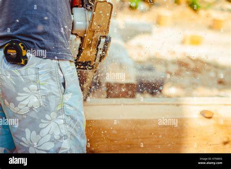 Man With A Chainsaw Cutting A Tree For Construction Stock Photo Alamy