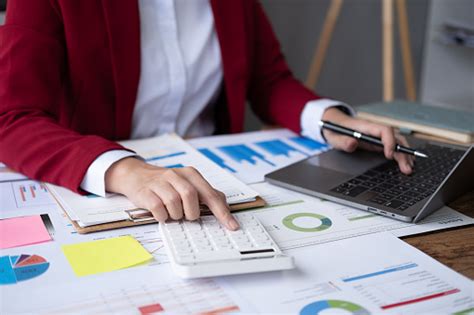 젊은 아시아의 행복한 전문 여성 사업가 직원이 사무실 책상에 앉아 컴퓨터와 계산기 작업을 하고 회계사 계산 세금은 컴퓨터에 회사 법률 계정을 세운다 30 34세에 대한 스톡