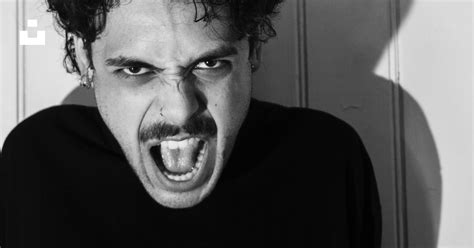 입을 벌리고 있는 남자와 그의 뒤에 있는 벽에 그림자가 드리워져 있다 사진 Unsplash의 무료 요술 이미지