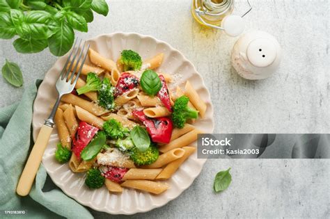 브로콜리와 빨간 구운 피망을 곁들인 통곡물 파스타 펜네와 밝은 회색 슬레이트 돌 또는 콘크리트 배경 비건 파스타 전통 이탈리아 요리 플랫 레이 공간 복사 0명에 대한 스톡