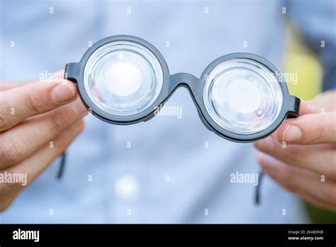 Man Holding Up Large Toy Glasses With Big Thick Lenses Simple Glasses In Hands Object Detail