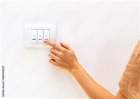 Reduction In Electricity Consumption Female Finger On Light Switch Close Up Stock Photo