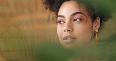 아프리카 메이크업 및 베이지 색 배경에 식물이있는 열대 스튜디오의 흑인 여성 패션 미용 및 화장품에 대한 모형 자연의 아름다움 아프리카 머리 및 보석을 가진 모델의 초상화