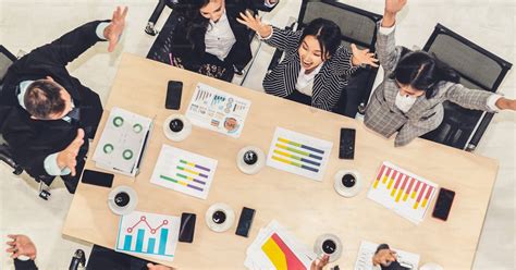 성공적인 사업가들은 사무실 테이블에서 기쁨으로 함께 축하합니다 젊은 사업가와 사업가 노동자들은 팀워크로 성공을 보여주는 쾌활한 승리를 표현합니다 사진 Unsplash