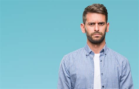 문제가 격리 된 배경 의심과 긴장 찡그림 화가 흰색 T셔츠를 입고 젊은 잘생긴 남자 부정적인 사람입니다 T 셔츠에 대한 스톡 사진 및 기타 이미지 Istock