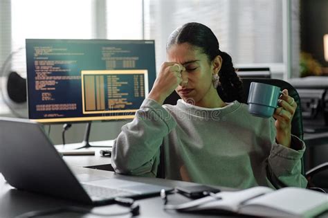 Exhausted Female Programmer Touching Face Sitting At Working Desk In Office Stock Image Image