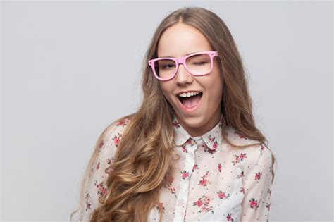 물결 모양의 금발 머리를 가진 여자가 서서 장난스럽게 윙크하고 긍정적인 표정을 지으며 카메라를 바라보고 있다 경외감에 대한 스톡 사진 및 기타 이미지 Istock