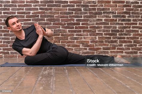 발랄 한 매력적인 젊은 남자 운동 요가 필 라 테 스 휘트니스 교육 아사 나 Valakhiliasana 벽돌 벽 배경 위에 스튜디오 촬영 전체 길이 강사에 대한 스톡 사진