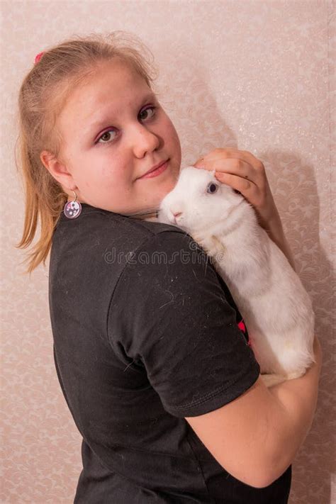 девушка держит красивого белого кролика на руках Стоковое Фото изображение насчитывающей лимб