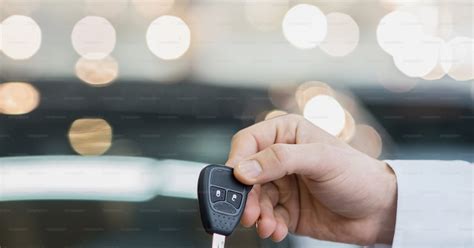 차 앞에 서 있는 동안 자동차 소유자에게 열쇠를 주는 남자의 클로즈업 사진 Unsplash의 사업 이미지