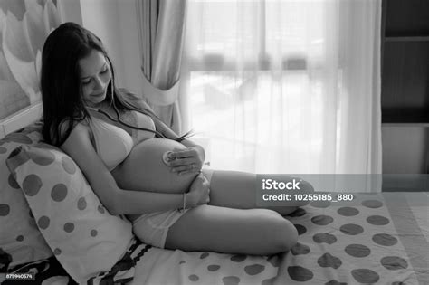 아름 다운 임산부 흰색과 검은색 스타일에서 침대에 Listning 아기에 게 청진 기를 사용 하 여 건강관리와 의술에 대한 스톡