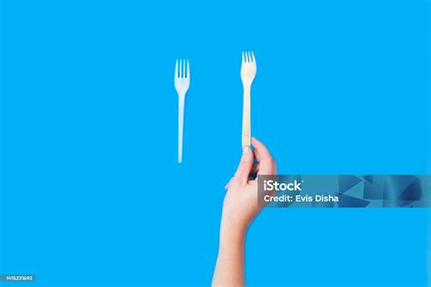 에코 천연 대나무 포크를 들고 있는 여자 손 플라스틱 포크 대 재사용 가능한 Bomboo 비교 개념 파란색 배경에 평평하게 누워 있습니다 지속 가능한 라이프 스타일 개념