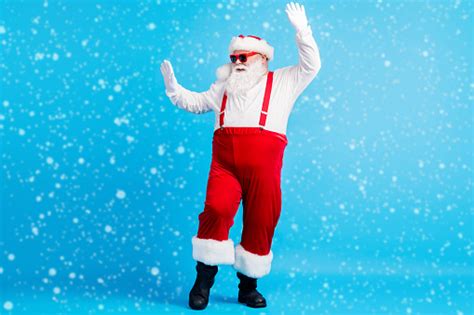 큰 배꼽 수염 댄스 Xmas 크리스마스 새해 유쾌한 디스코텍 착용 멜빵 바지 선글라스 절연 블루 컬러 배경을 가진 세련 된 펑키 뚱뚱한 산타 클로스의 전신 사진 12월에