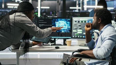 Admin In Wheelchair And Data Center Coworker Work Together Using Node