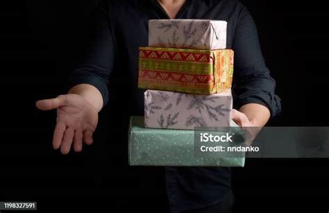 검은 셔츠를 입은 성인 남성이 종이로 감싼 선물을 손에 들고 있다 갈색에 대한 스톡 사진 및 기타 이미지 갈색 검은색 기념일 Istock