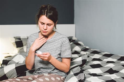 주제는 계절 감기 콧 물 코 독감 바이러스 감염 홈 침실 침대에 젊은 백인 여자 코 딱지에 대 한 그녀의 코에 의학의 스프레이 방울을 사용합니다 축 농 증 및 알레르기