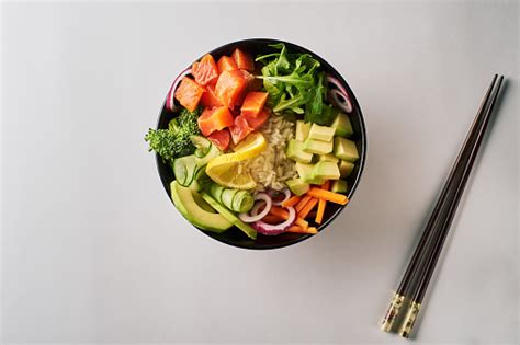 흰색 배경 위에 절연 젓가락으로 그릇 연어 아보카도 오이 Arugula 브로콜리 쌀 당근 달콤한 양파와 고추 상위 뷰 포케 음식에 대한 스톡 사진 및 기타 이미지 Istock