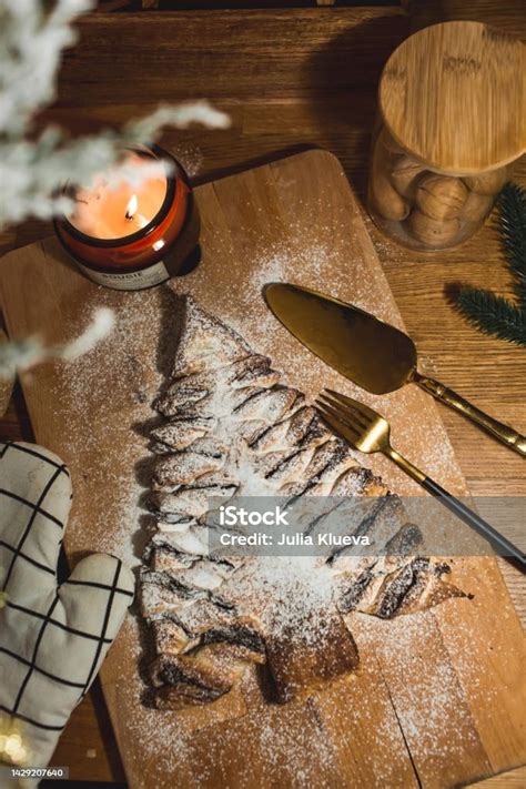 새해 테이블 손님을위한 간식 나무 배경에 크리스마스 트리 형태로 초콜릿을 곁들인 퍼프 패스트리 케이크 가족 휴가의 개념 텍스트에 대한 공간의 복사본입니다 0명에 대한 스톡