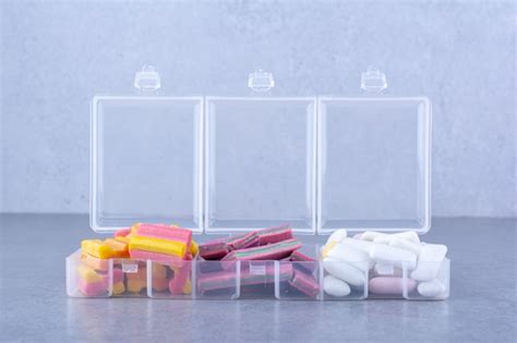 씹는 껌 큐브 스트립 및 정제는 대리석 표면에 작은 상자로 깔끔하게 분류됩니다 무료 사진