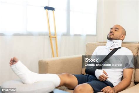 행복한 남자 사고 골절에서 회복 부러진 뼈 부상 캐스트 넥 부목 칼라 팔 부목 슬링 지원 팔에 다리 부목이 거실에서 사회 보장 및 건강 보험 개념 부러진 다리에 대한 스톡