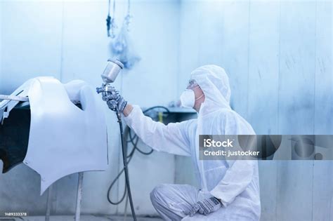 스프레이 건과 에어 브러시를 사용하고 자동차를 칠하는 작업자 챔버에서 자동차를 페인트 칠하는 기계공 차고 페인트 자동차 서비스