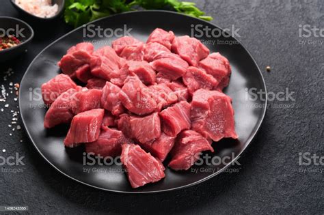 생 다진 쇠고기 고기 생 유기농 고기 쇠고기 또는 양고기 향신료 어두운 회색 콘크리트 배경에 검은 접시에 허브 굴라쉬 날것으로 조리되지 않은 고기 피가 든 고기 복사 공간이