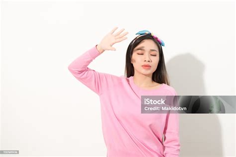 밝은 태양 빛의 손으로 얼굴을 덮고 아름 다운 아시아 여자의 초상화입니다 태양 광에서 그녀의 얼굴을 보호 하는 분홍색 드레스에