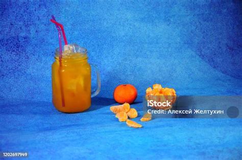 얼음과 빨대가 있는 귤 주스 잔에 과일이 있고 파란 배경에 조각이 있습니다 0명에 대한 스톡 사진 및 기타 이미지 0명 가득 찬 감귤 Istock